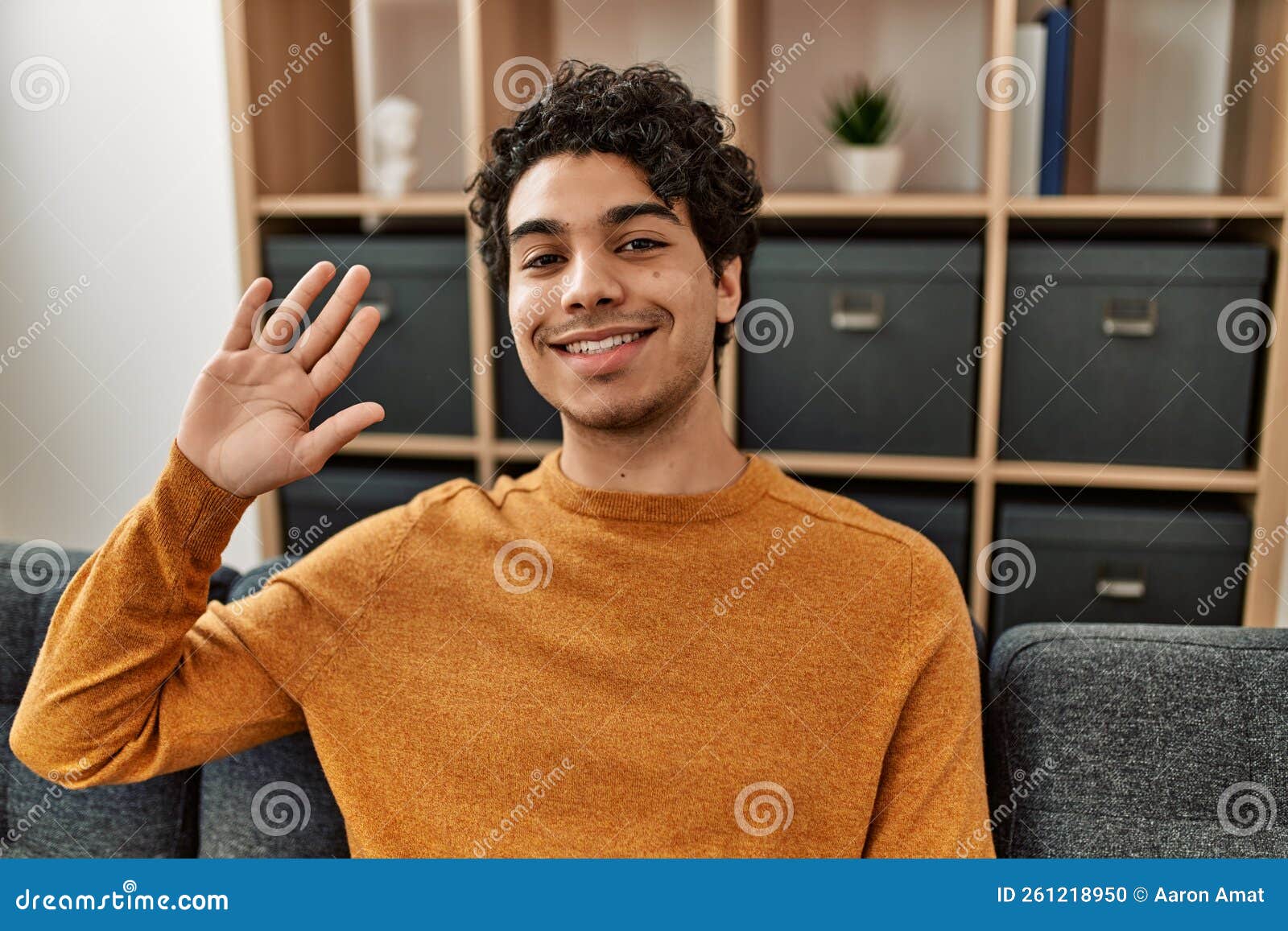 Young Hispanic Man Smiling Happy Saying Hello Sitting on the Sofa at ...