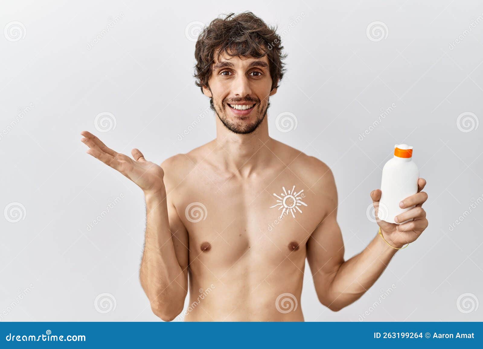 Young Hispanic Man Standing Shirtless Holding Sunscreen Lotion Smiling