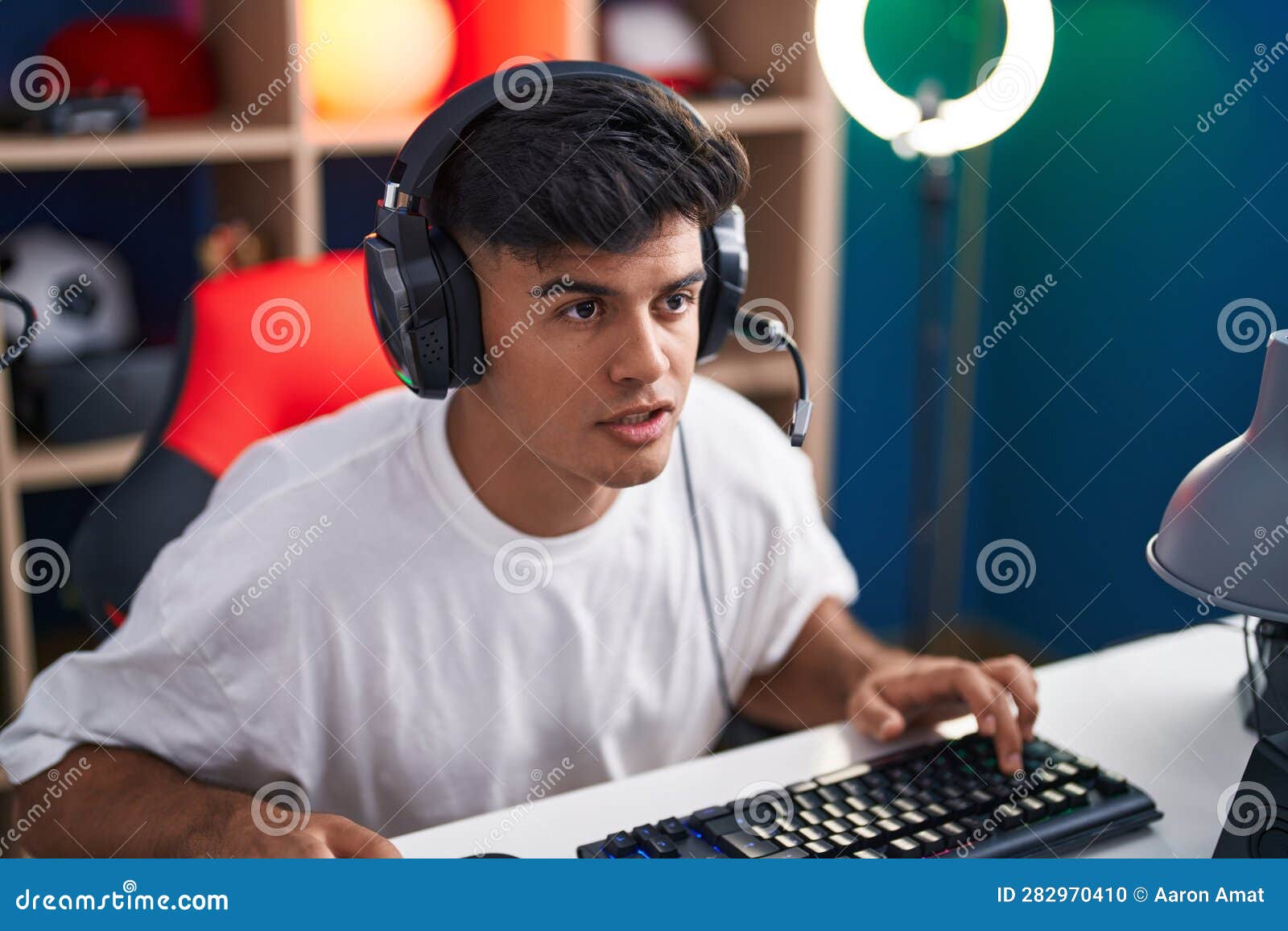 Young Hispanic Man Streamer Playing Video Game Using Computer at Gaming ...
