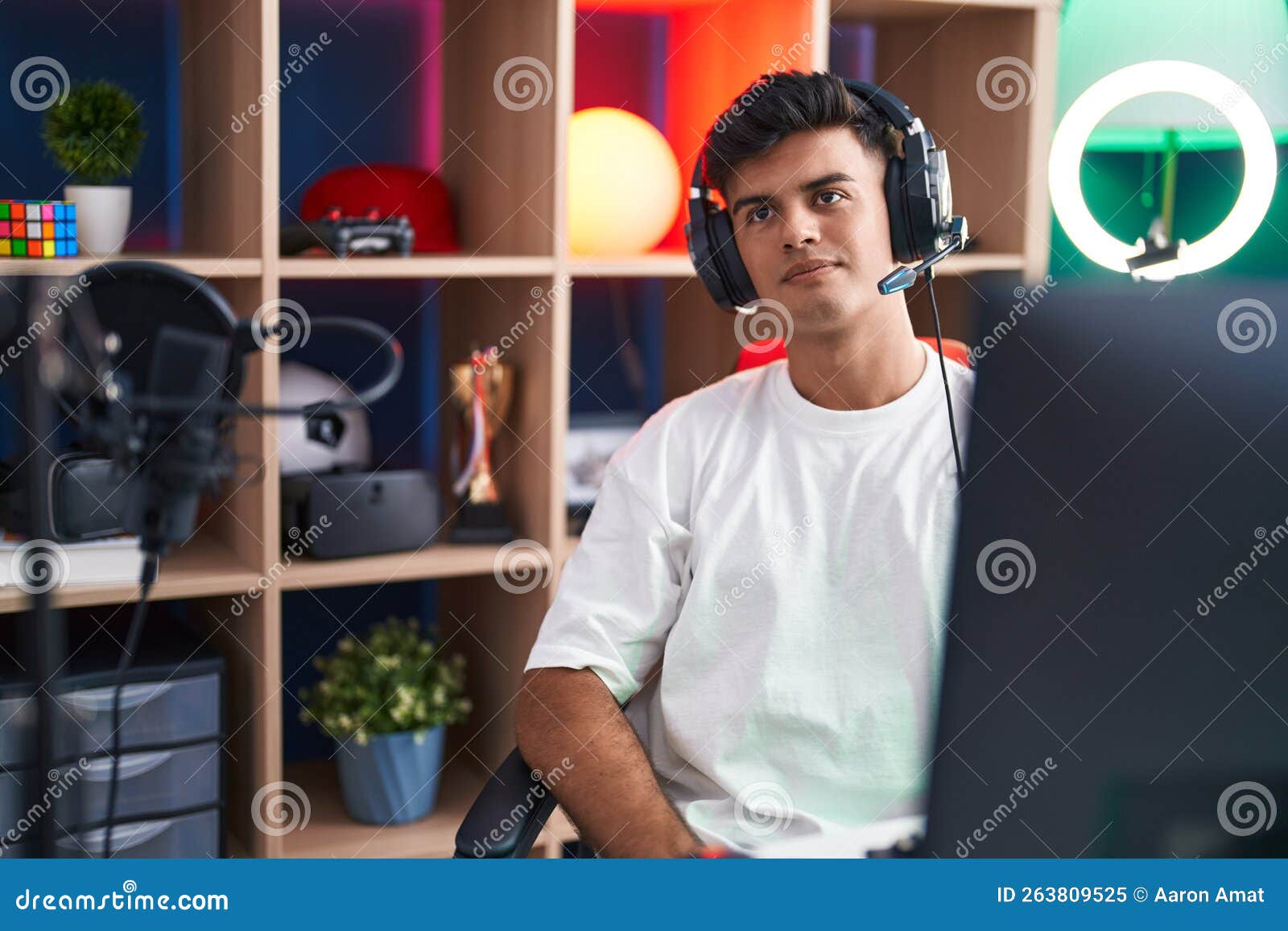 Young Hispanic Man Streamer Sitting on Table with Relaxed Expression at ...