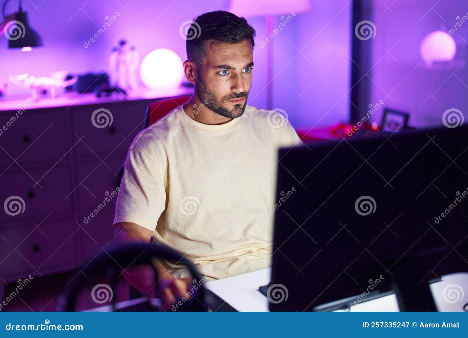 Young Hispanic Man Streamer Sitting on Table with Serious Expression at ...