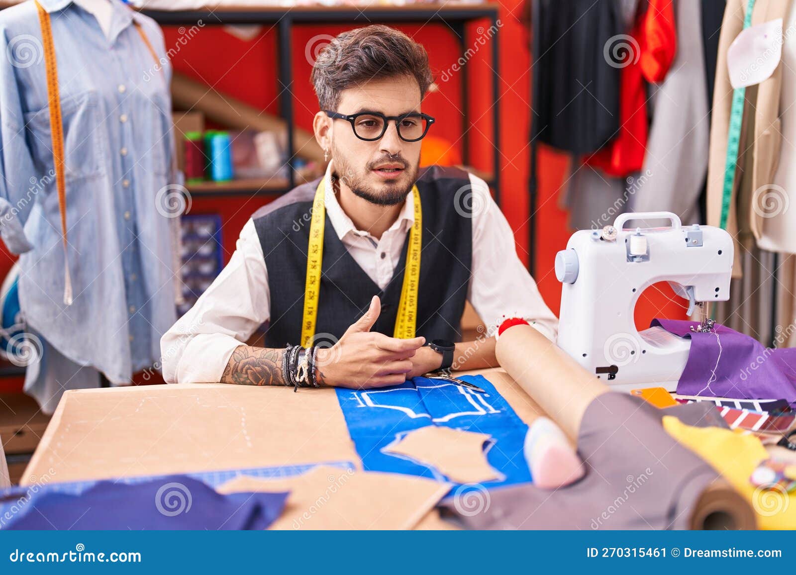 Young Hispanic Man Tailor Sitting on Table Speaking at Atelier Stock ...