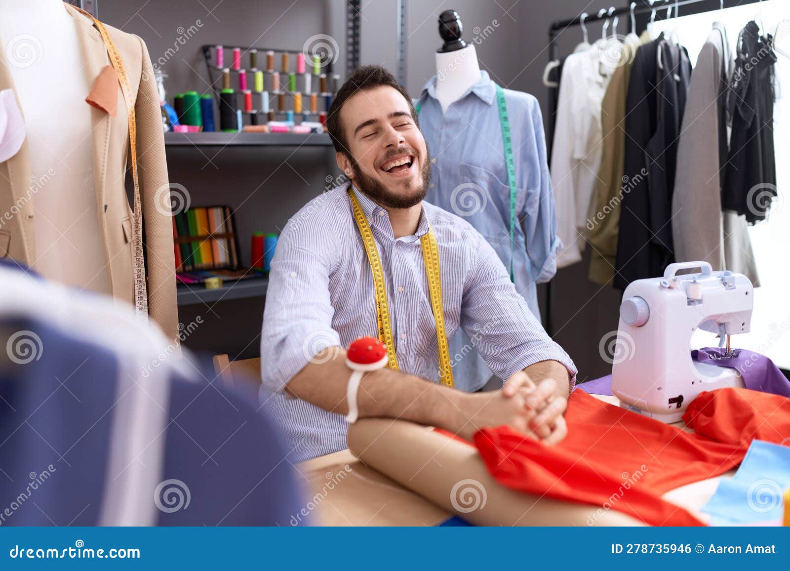 Young Hispanic Man Tailor Sitting on Table Speaking at Atelier Stock ...