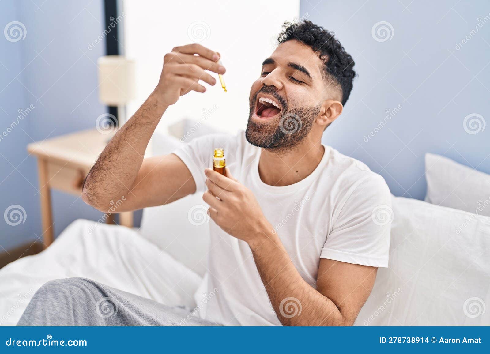 Young Hispanic Man Taking Syrup Sitting on Bed at Bedroom Stock Photo ...
