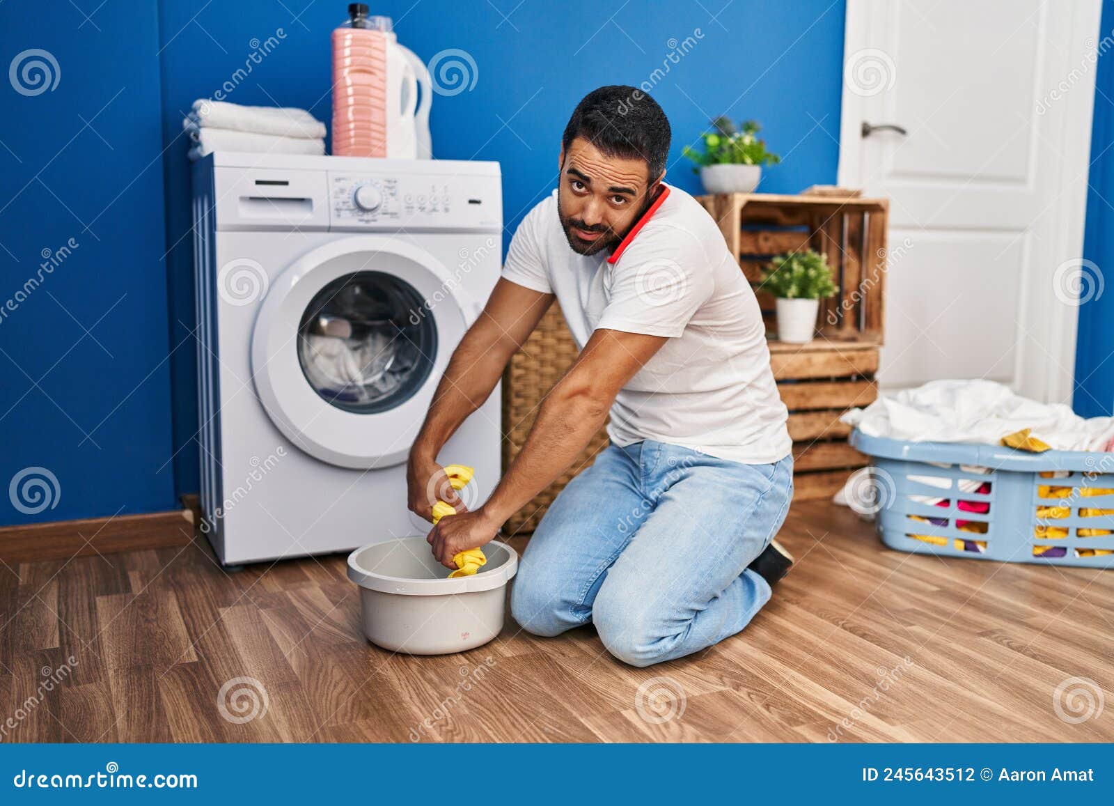 Young Hispanic Man Talking on the Smartphone Wringing Out Rag at ...