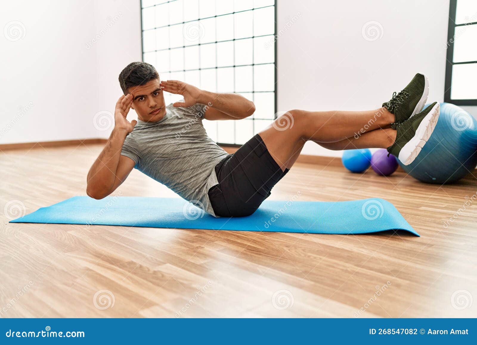 Young Hispanic Man Training Abs Exercise at Sport Center Stock Photo ...