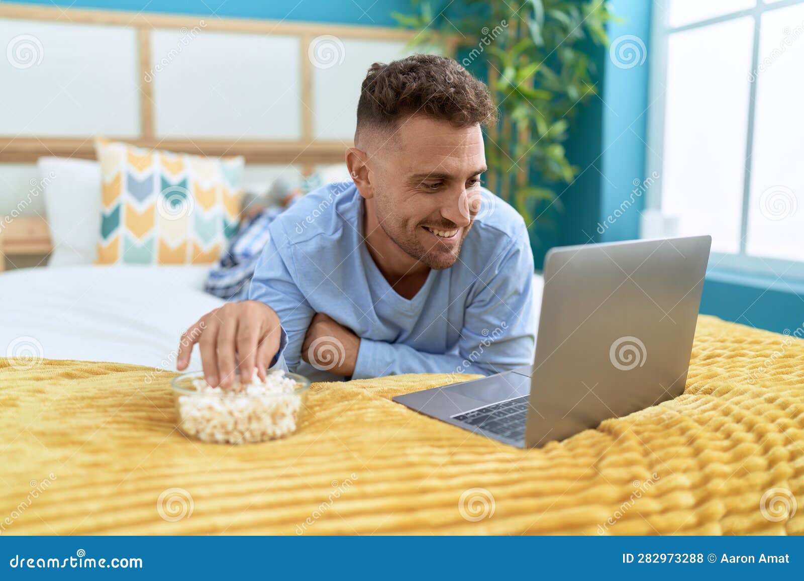 Young Hispanic Man Watching on Laptop Lying on Bed at Bedroom Stock ...