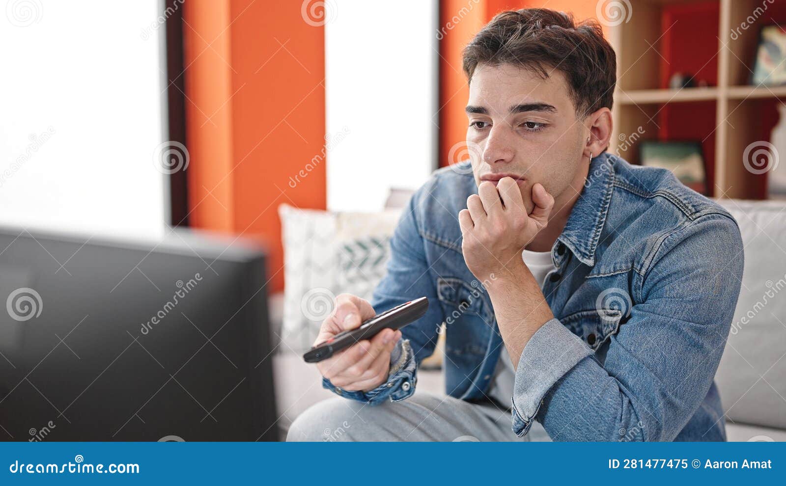 Young Hispanic Man Watching Tv Sitting on Sofa with Boring Expression ...