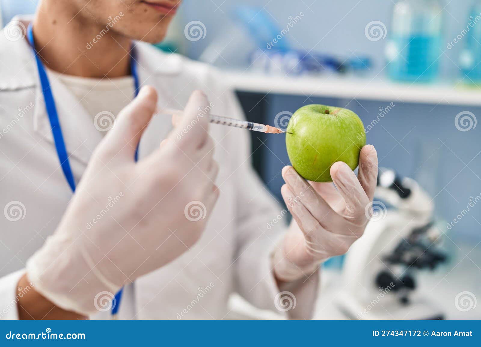 Young Hispanic Man Wearing Scientist Uniform Injecting on Apple at ...