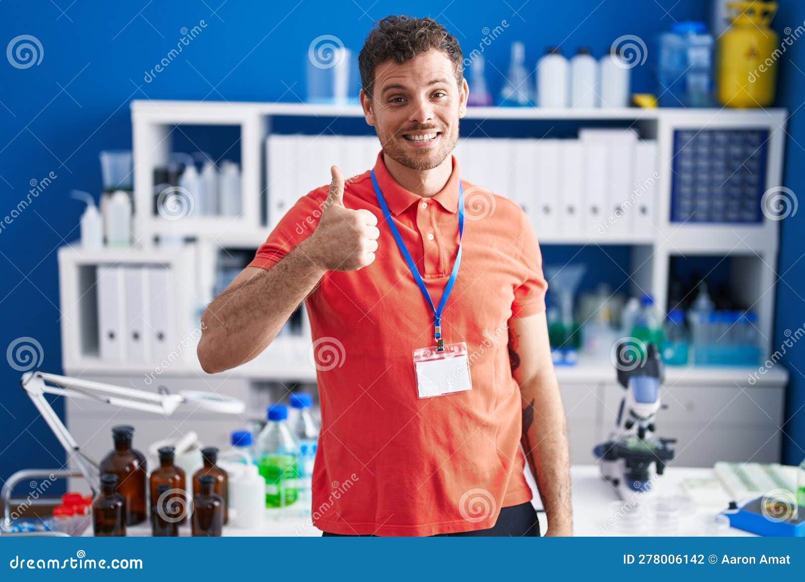 Young Hispanic Man Working at Scientist Laboratory Doing Happy Thumbs ...