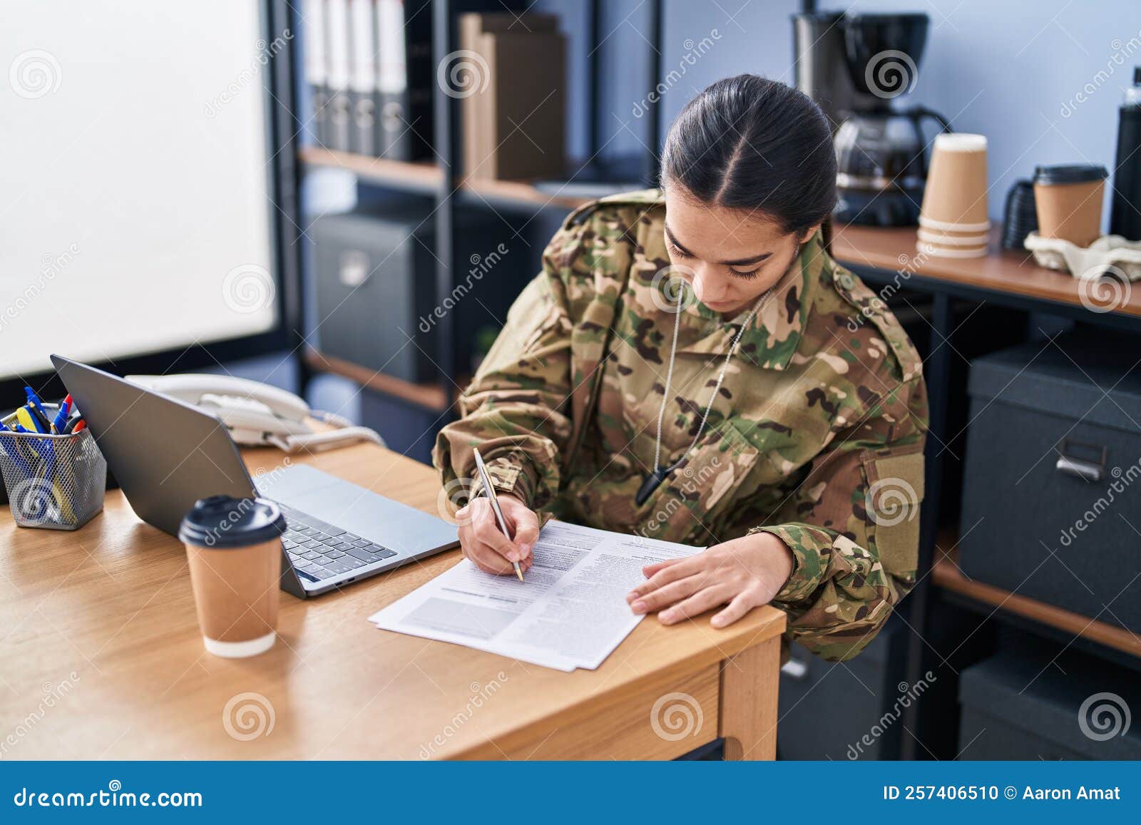 Young Hispanic Woman Army Soldier Using Laptop Writing on Document at ...