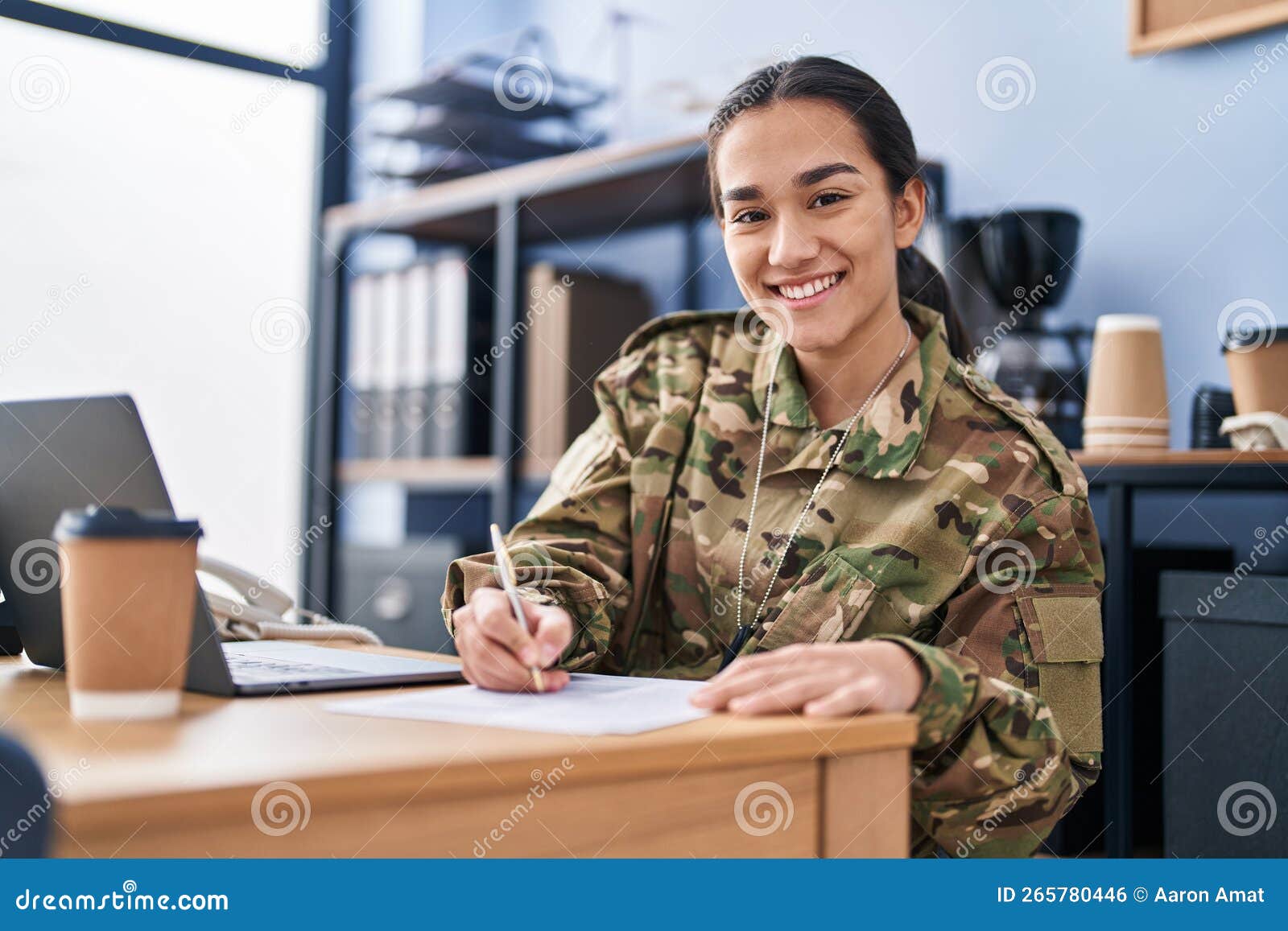 Young Hispanic Woman Army Soldier Using Laptop Writing on Document at ...