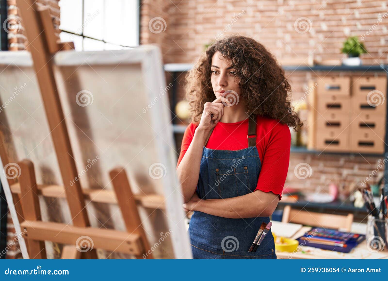 Young Hispanic Woman Artist Looking Draw with Doubt Expression at Art ...