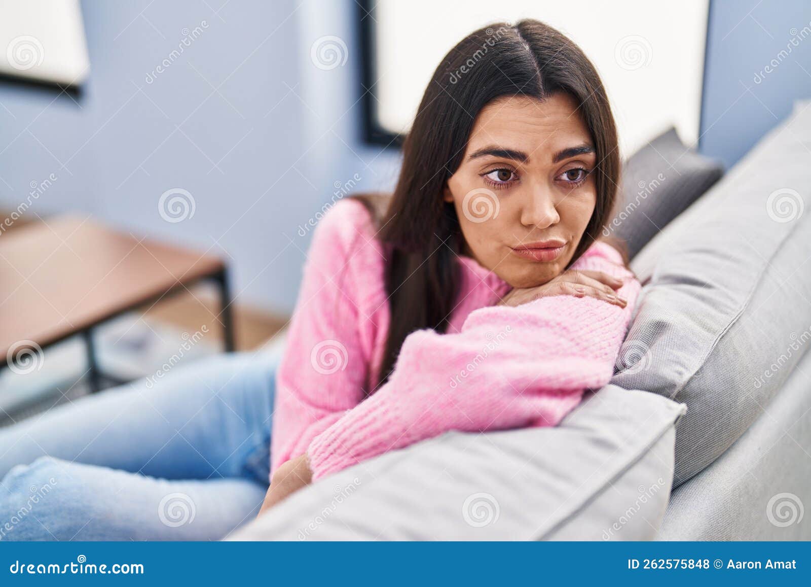Young Hispanic Woman with Boring Expression Sitting on Sofa at Home ...
