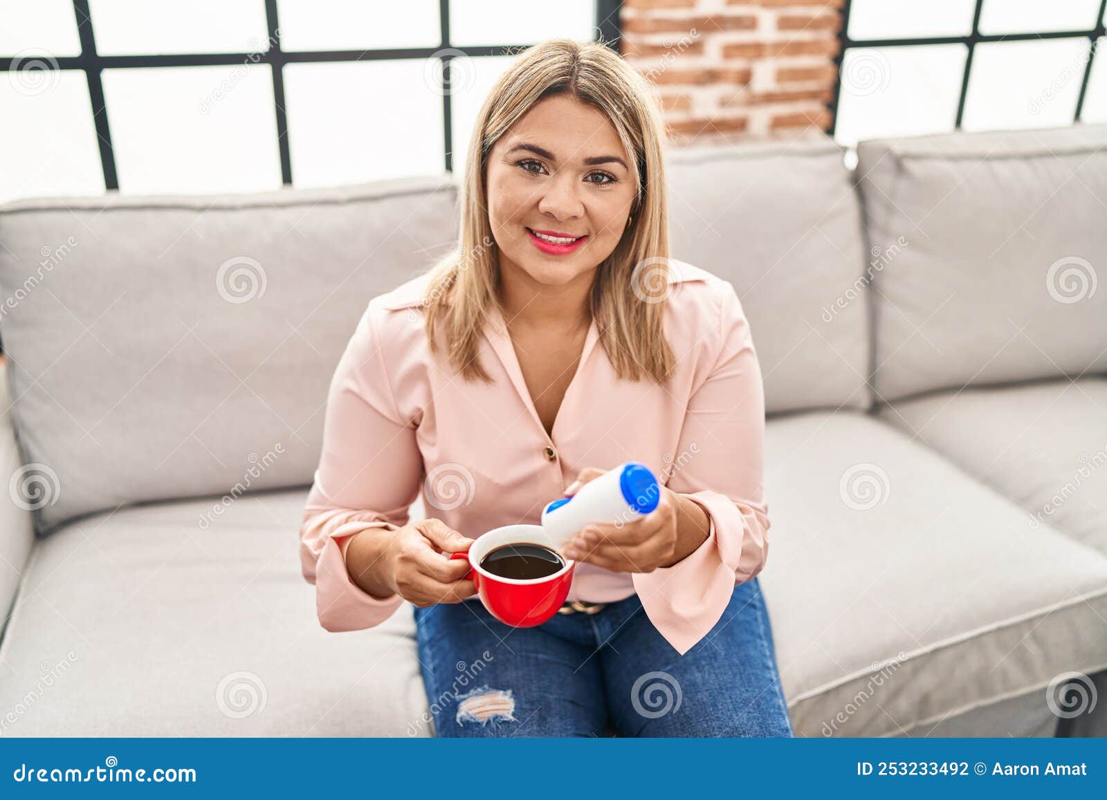 Young Hispanic Woman Drinking Coffee Sitting on Sofa at Home Stock ...