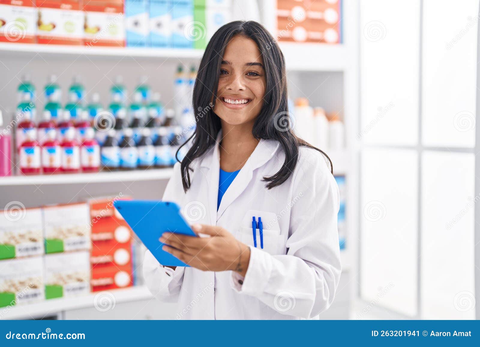 Young Hispanic Woman Pharmacist Using Touchpad Working at Pharmacy ...