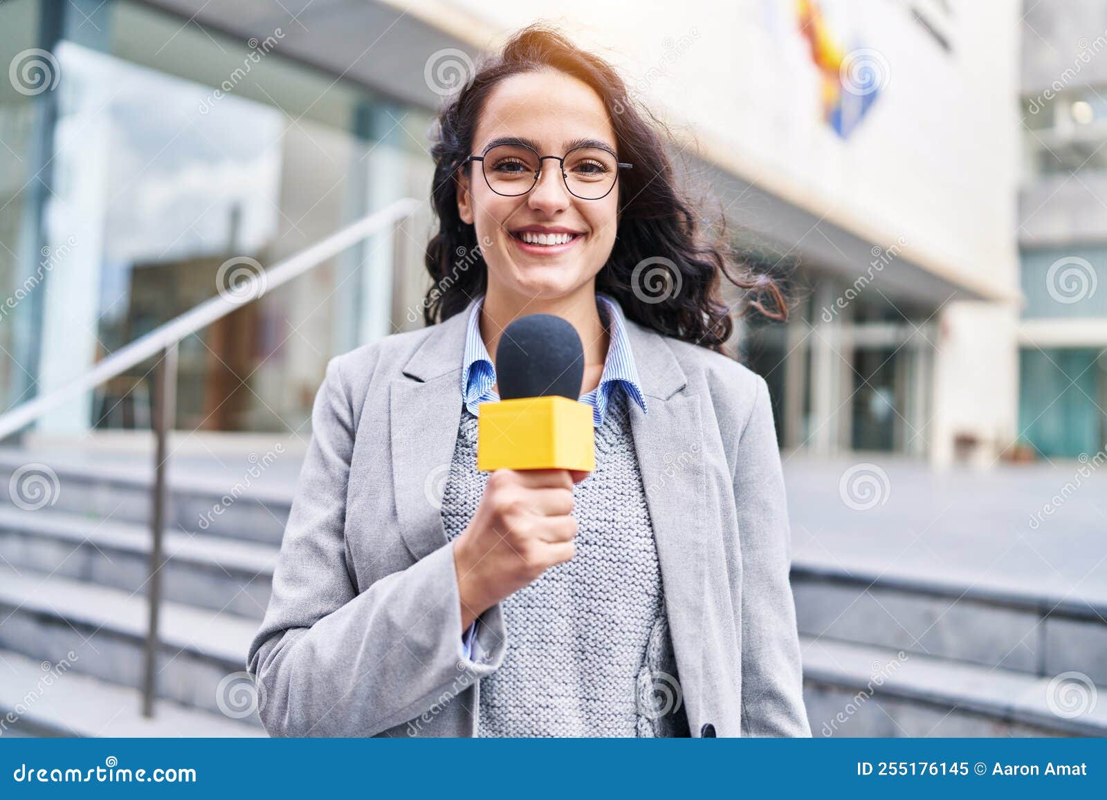 Young Hispanic Woman Reporter Working Using Microphone at Street Stock ...