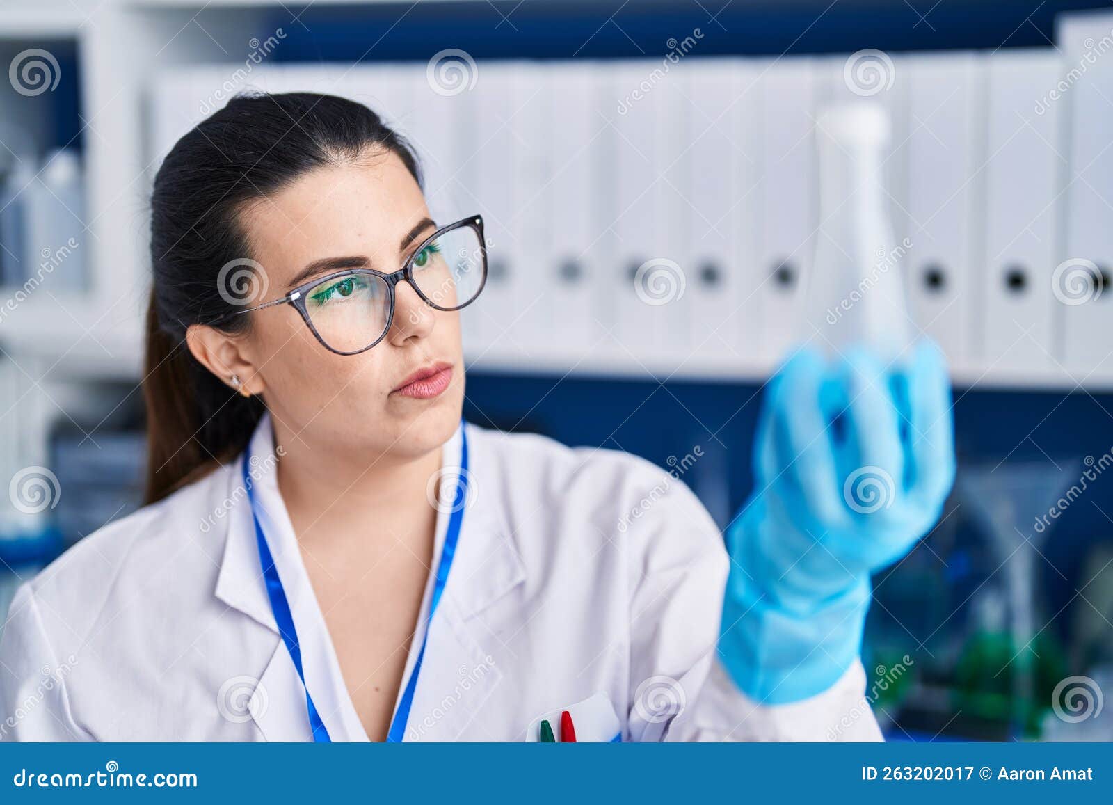 Young Hispanic Woman Scientist Measuring Liquid at Laboratory Stock ...