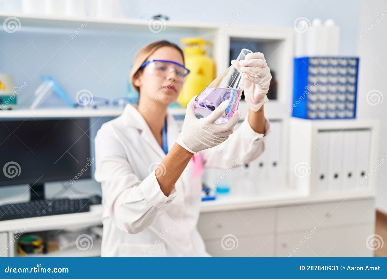 Young Hispanic Woman Scientist Measuring Liquid at Laboratory Stock ...