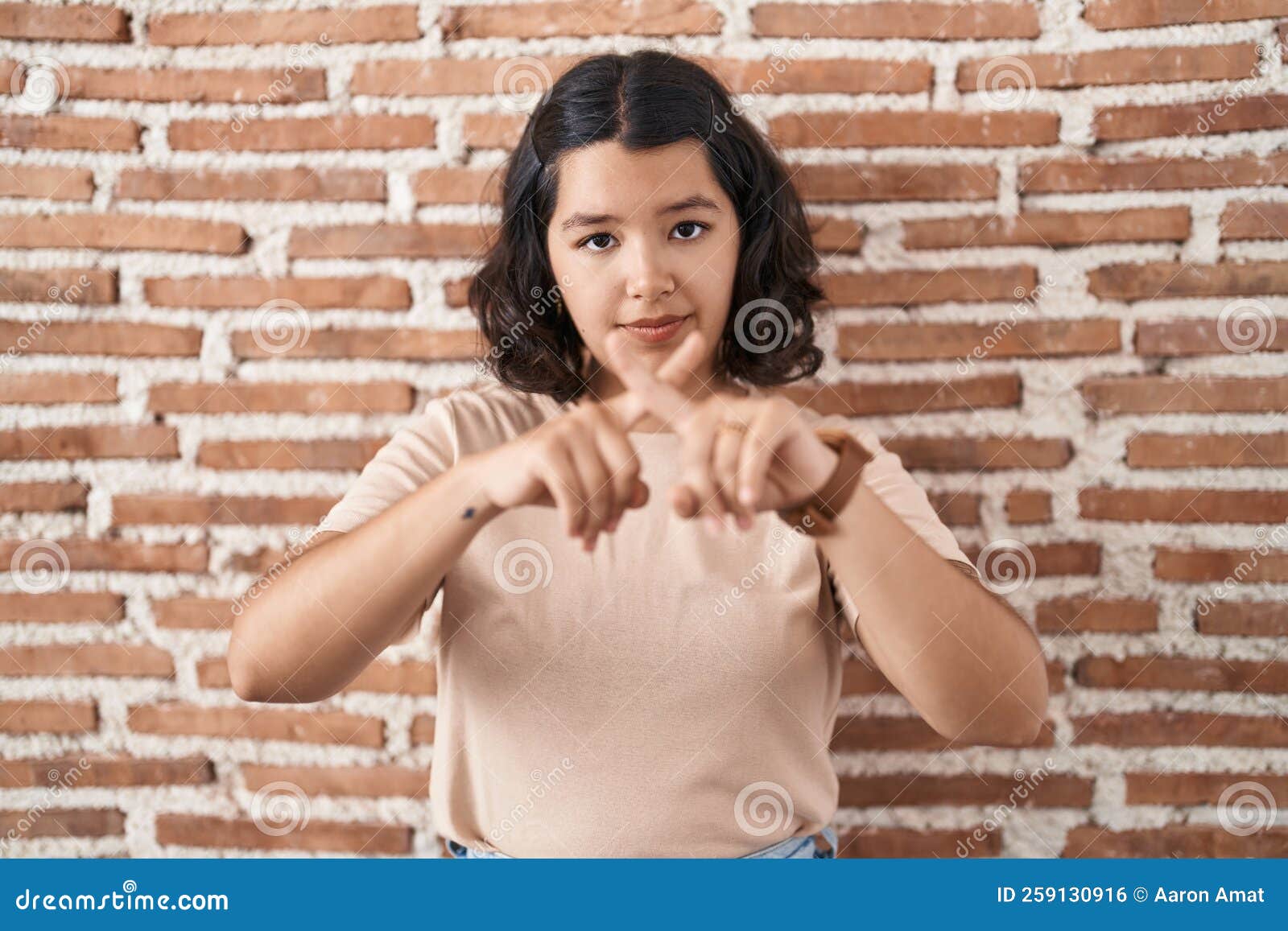 Young Hispanic Woman Standing Over Bricks Wall Rejection Expression