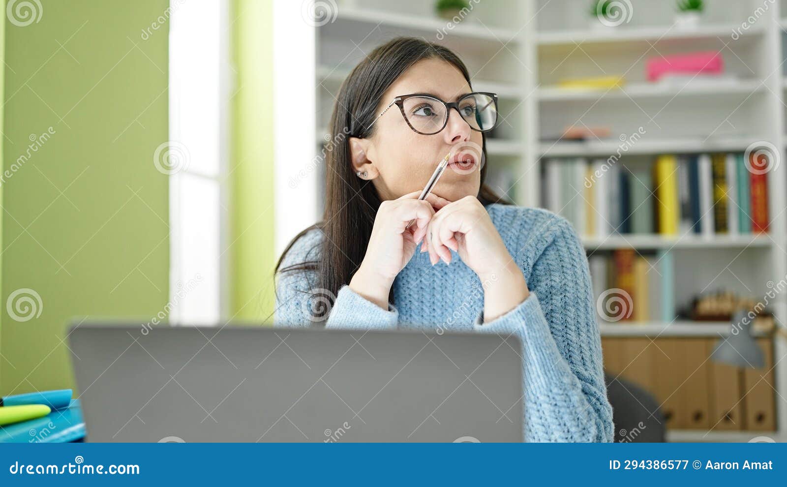 Young Hispanic Woman Student Using Computer Thinking at Library ...