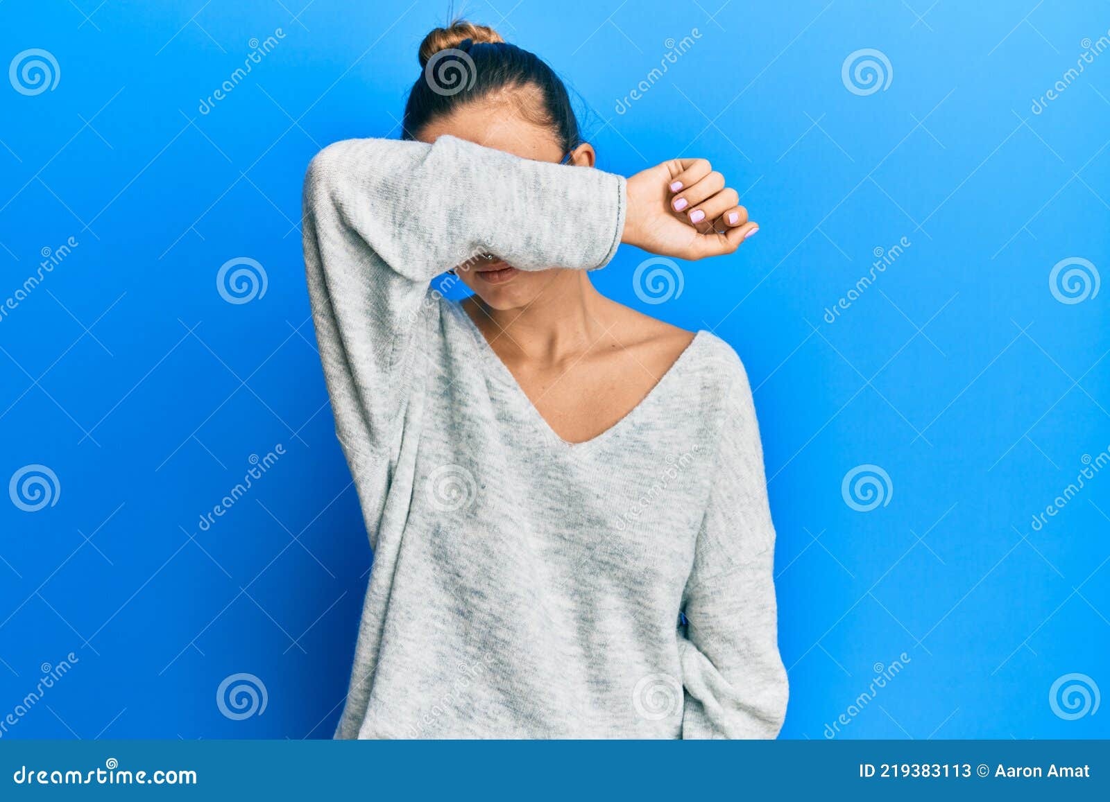 Young Hispanic Woman Wearing Casual Clothes Covering Eyes With Arm