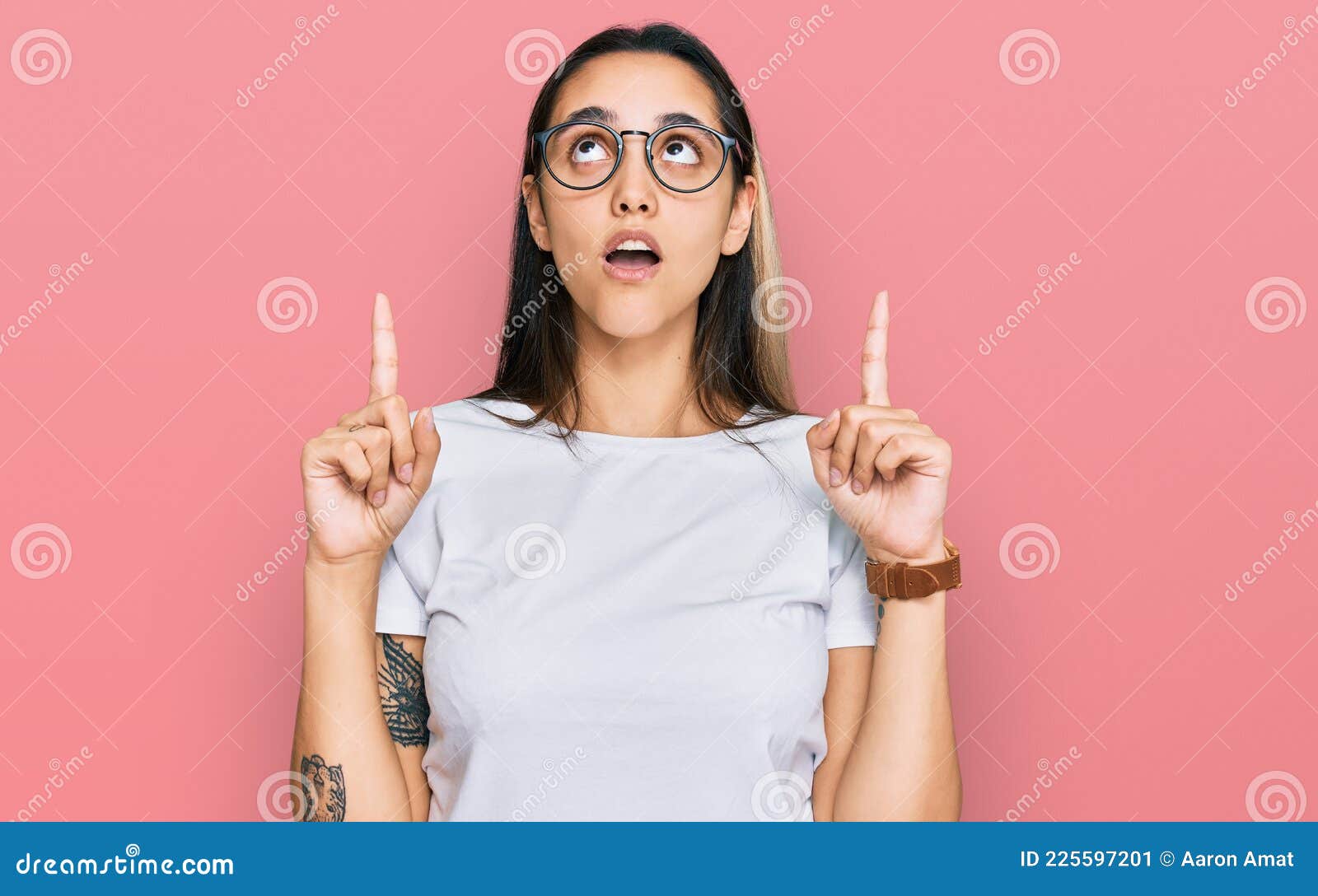 Young Hispanic Woman Wearing Casual White T Shirt Amazed And Surprised