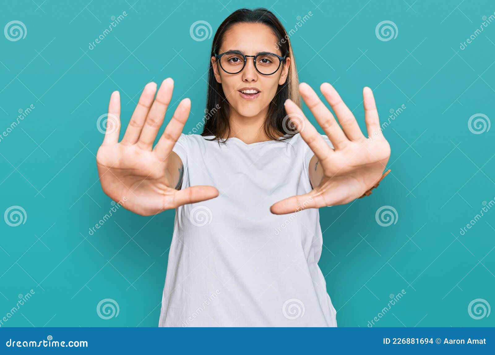 Young Hispanic Woman Wearing Casual White T Shirt Doing Stop Gesture
