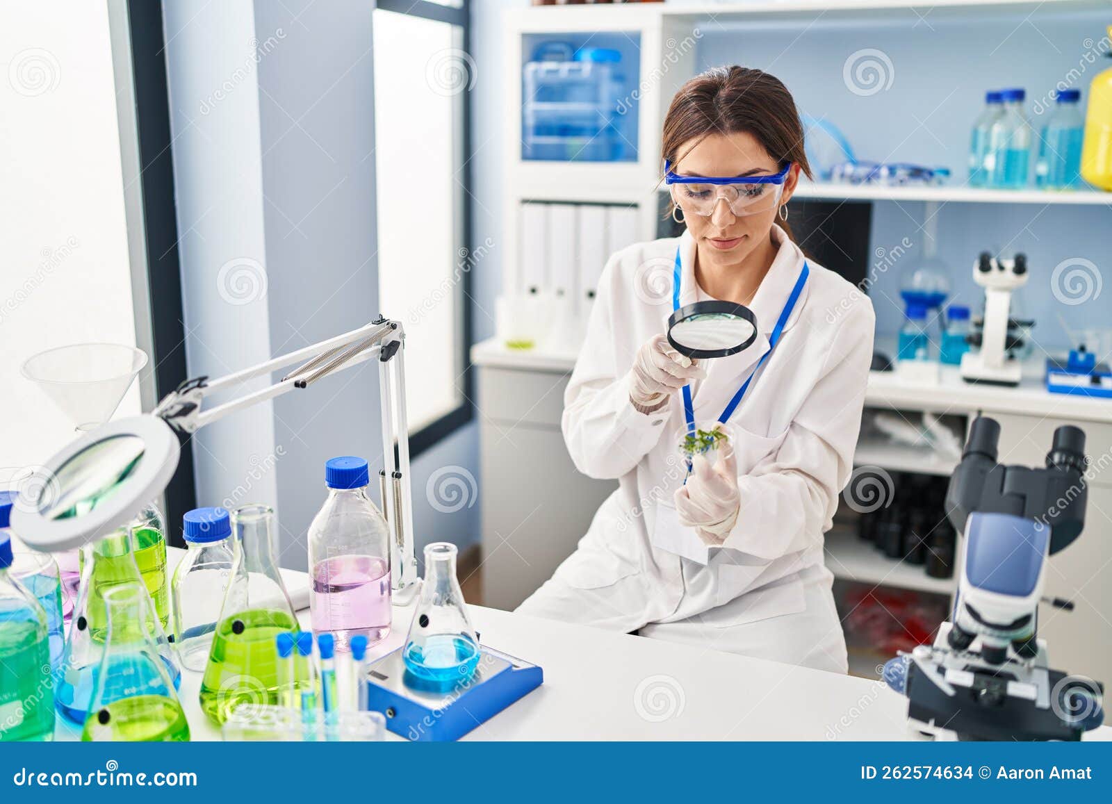 Young Hispanic Woman Wearing Scientist Uniform Using Magnifying Glass ...
