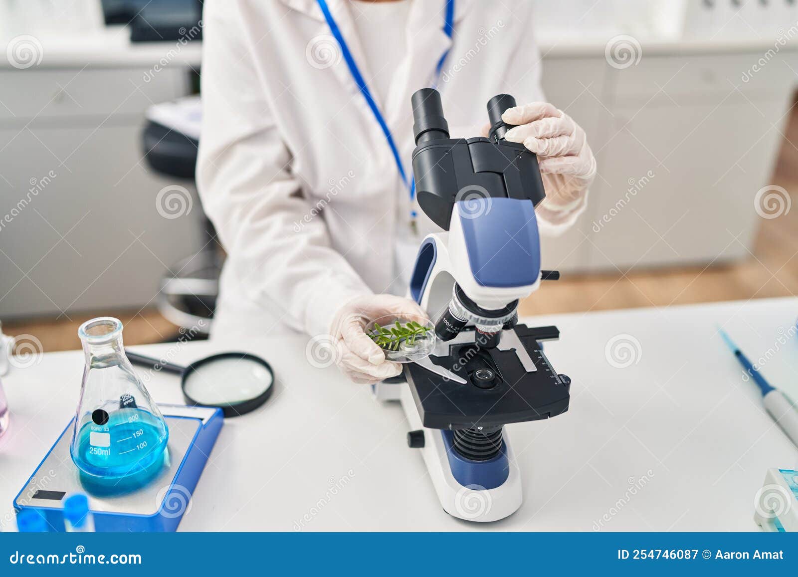 Young Hispanic Woman Wearing Scientist Uniform Using Microscope at ...