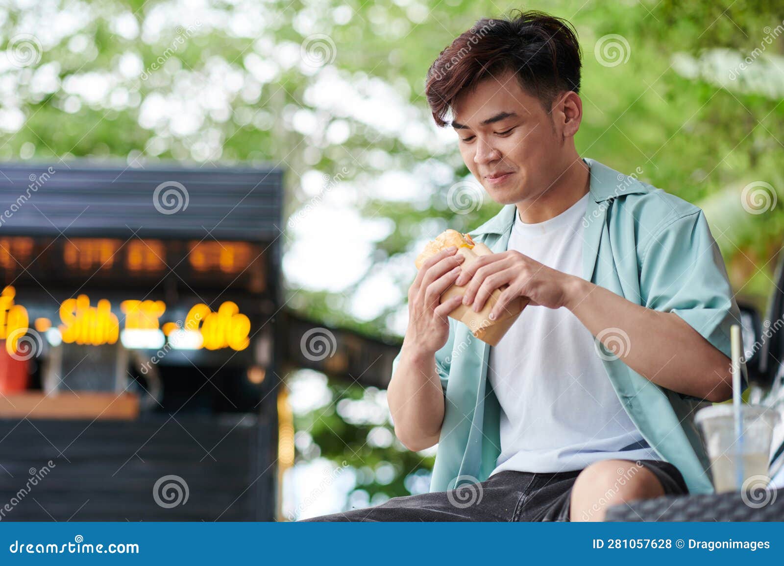 Young Hungry Asian Man Looking at Appetizing Hotdog in His Hands Stock ... Young Hungry Asian Man Looking at Appetizing Hotdog in His Hands Stock ...
