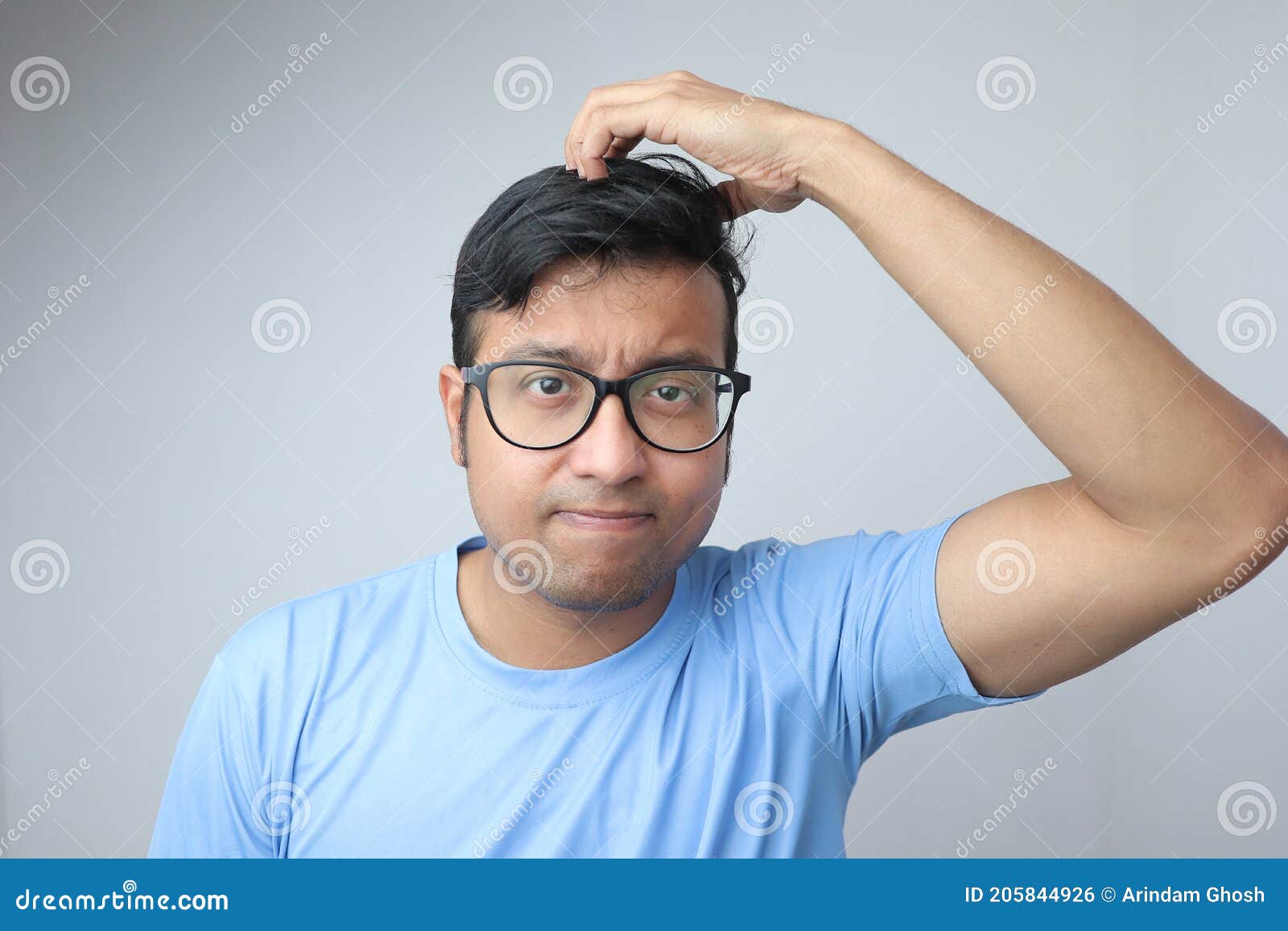 A Young Indian Man in Spectacles Scratching His Head and Looking ...
