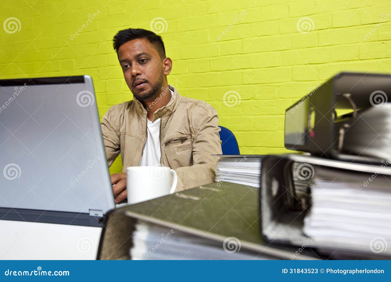 Young Indian Man Working at His Computer Surrounded by Folders Stock ...