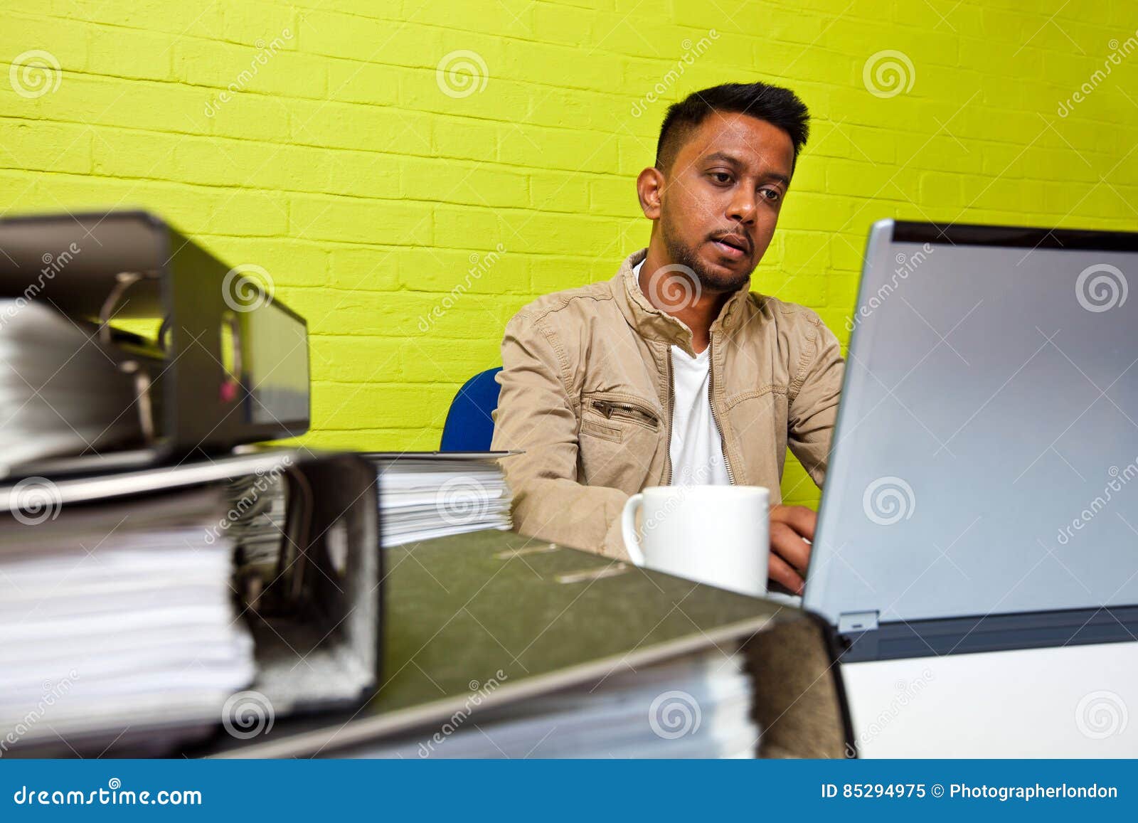 Young Indian Man Working at His Computer Surrounded by Folders Stock ...