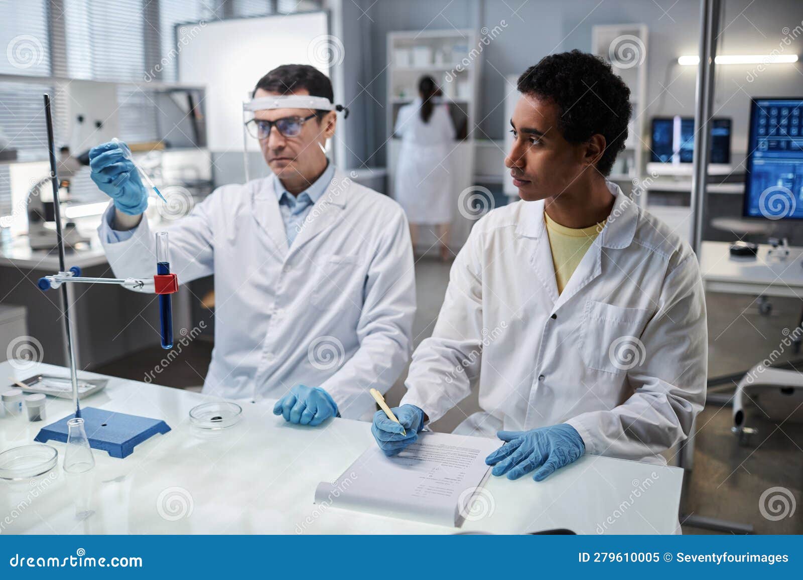 Young Intern in Scientific Laboratory Watching Male Scientist at Work ...