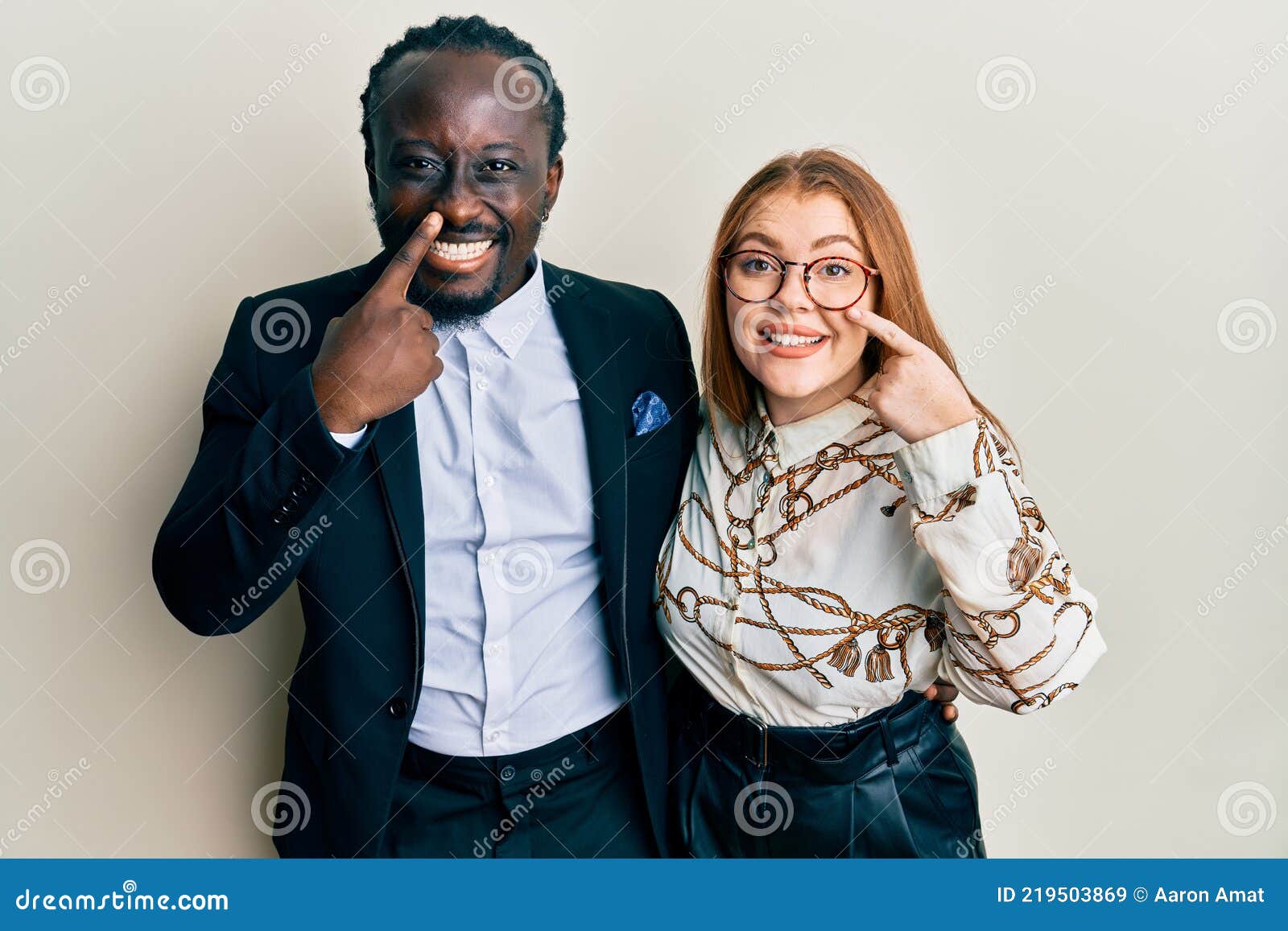 Young Interracial Couple Wearing Business And Elegant Clothes Pointing