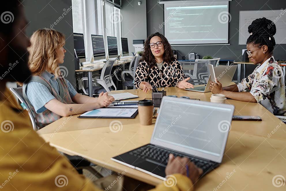 Young Colleagues Discussing it Project Sitting at Table in Office Stock ... Young Colleagues Discussing it Project Sitting at Table in Office Stock ...