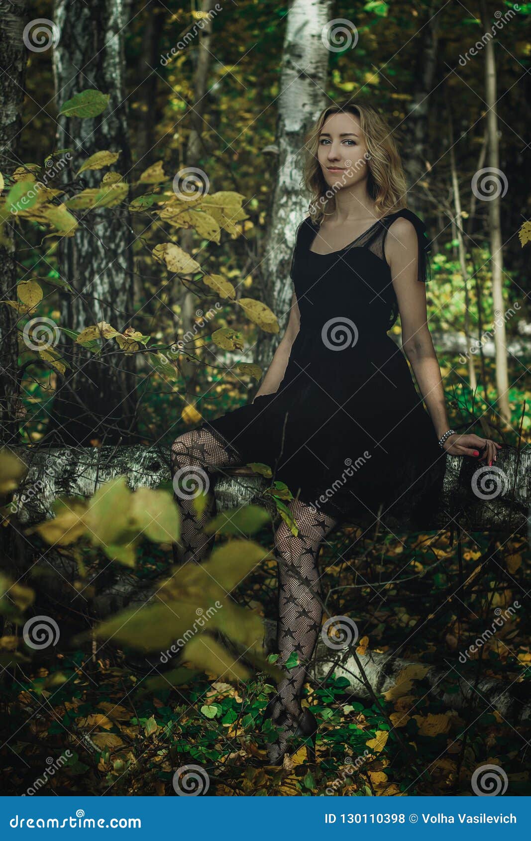 A Young Kind Witch in a Black Dress with a Black Mask in a Mystical ...