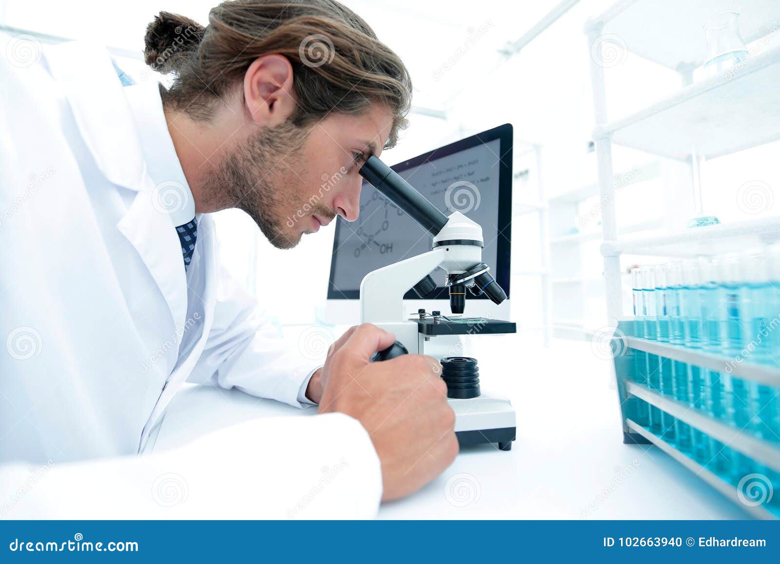 Young Laboratory Scientist Looking at Microscope in Laboratory Stock ...