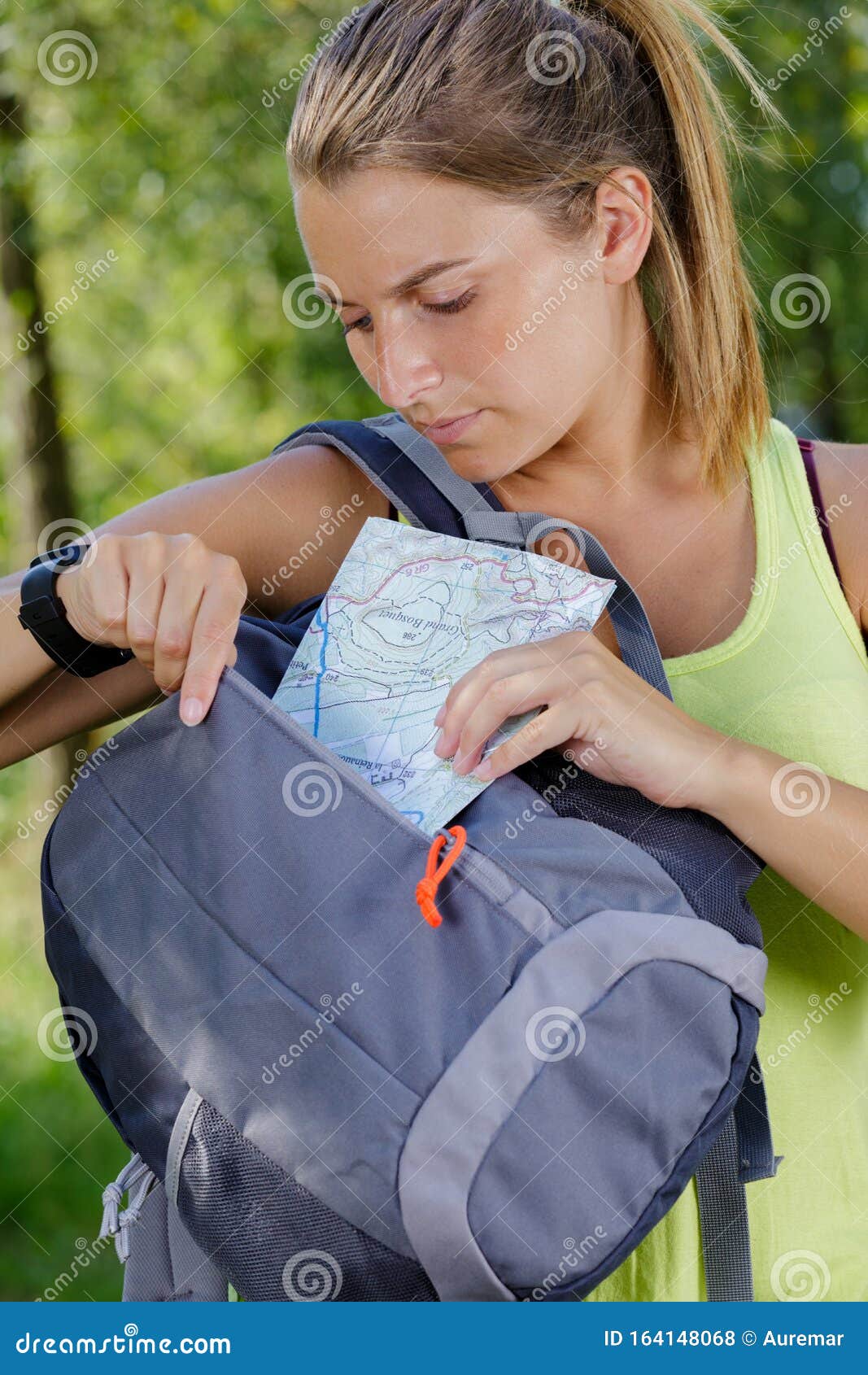 Young Lady Putting Map Back into Backpack Stock Photo - Image of ...