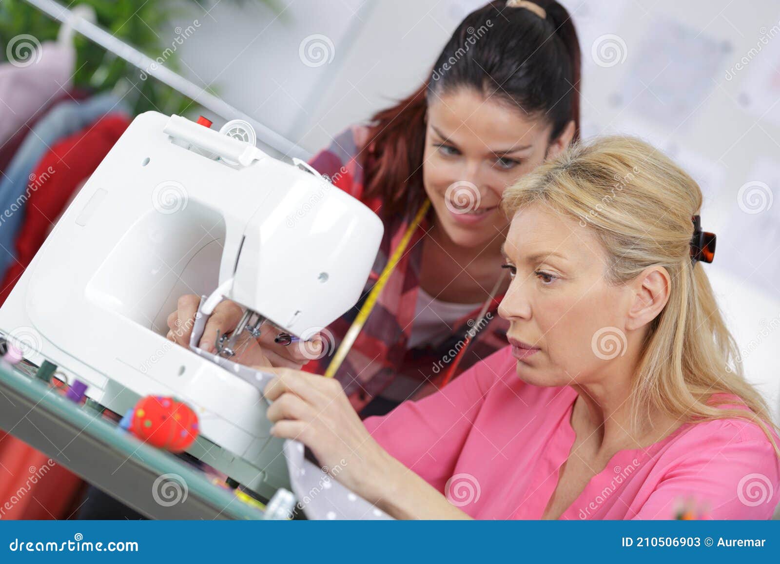 Young Lady Smiles As Older Lady Uses Sewing Machine Stock Image - Image ...