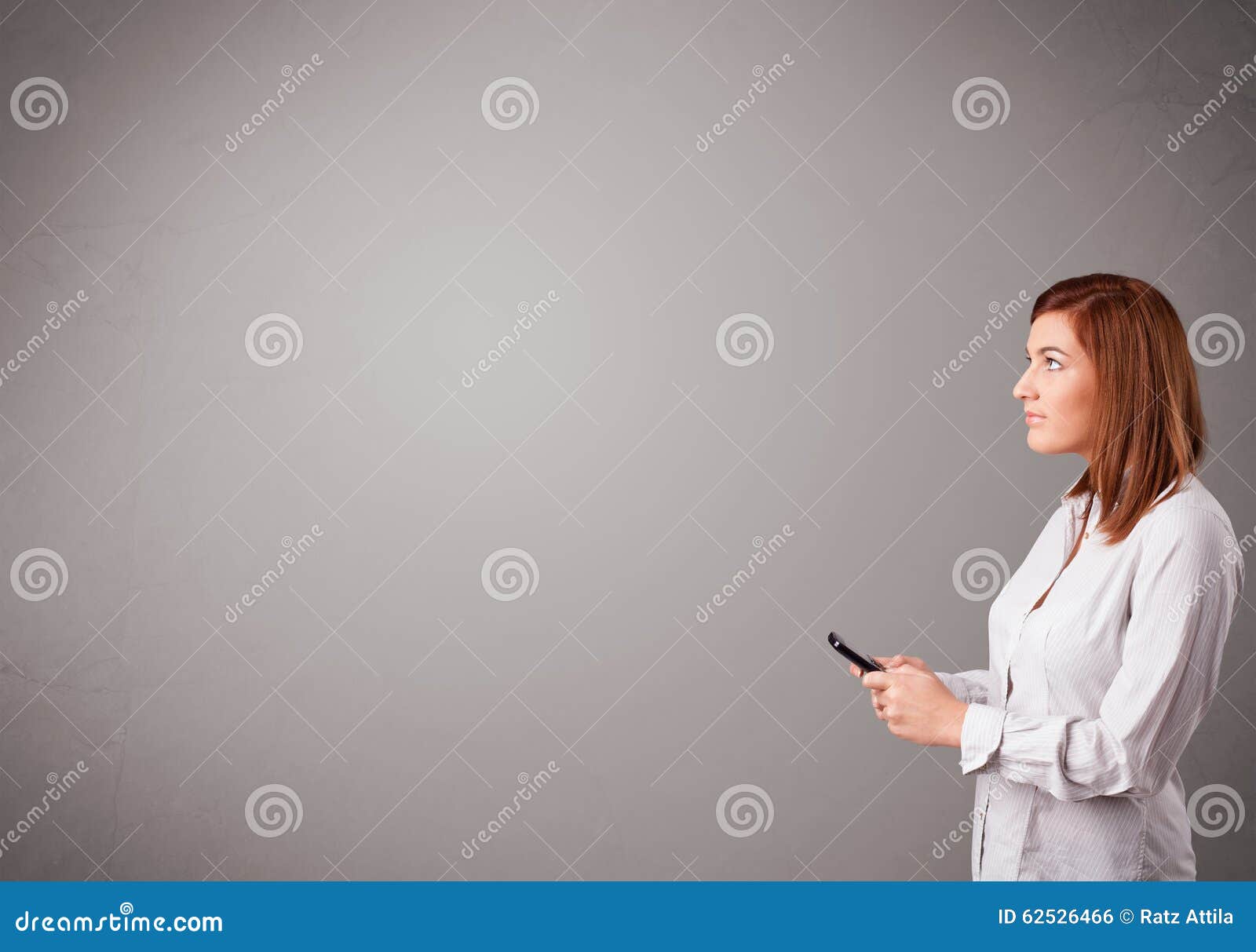 Young Lady Standing and Holding a Phone with Copy Space Stock Photo ...
