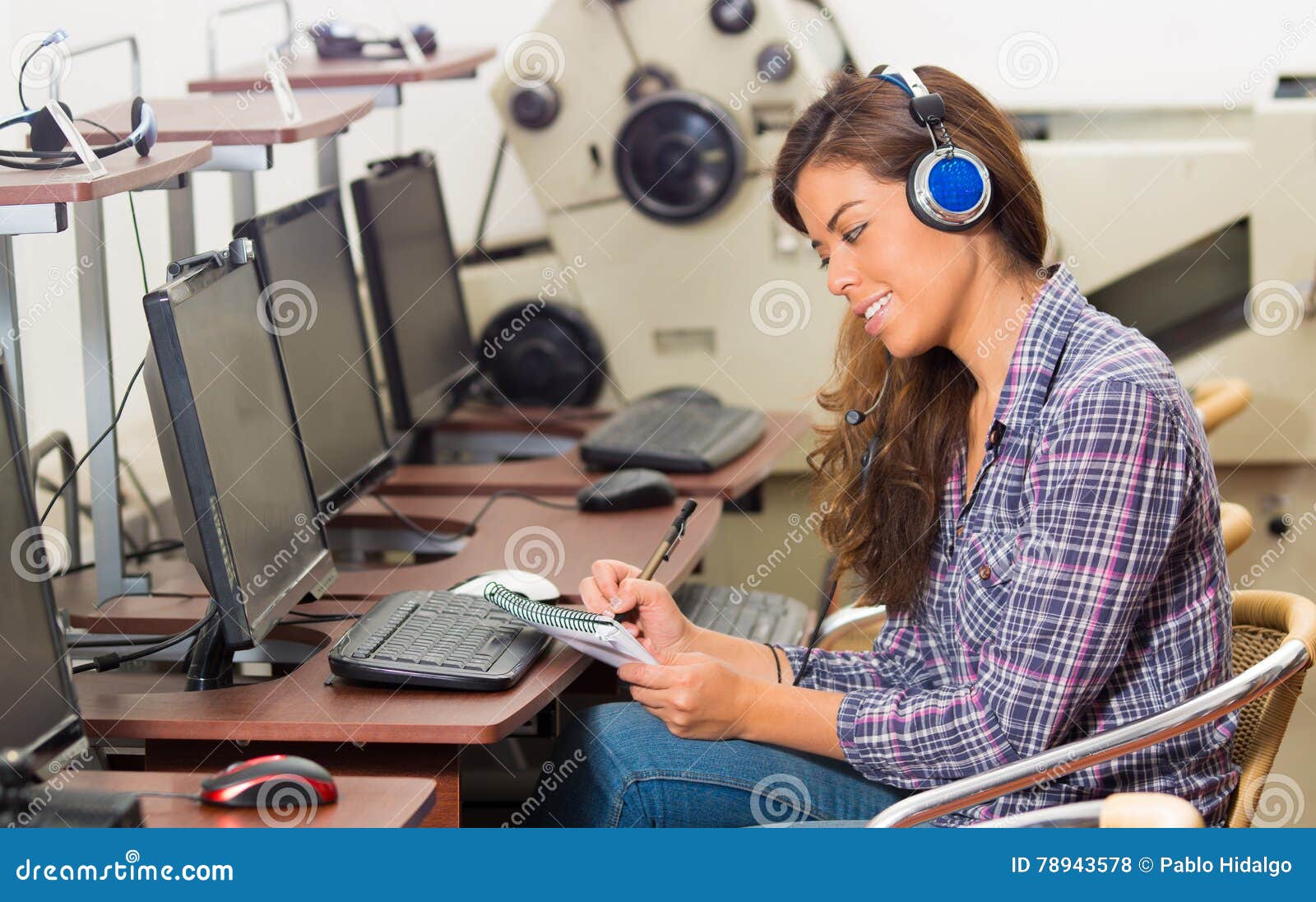 Young Lady Taking Notes while Talking with Someone on the Headset Stock ...
