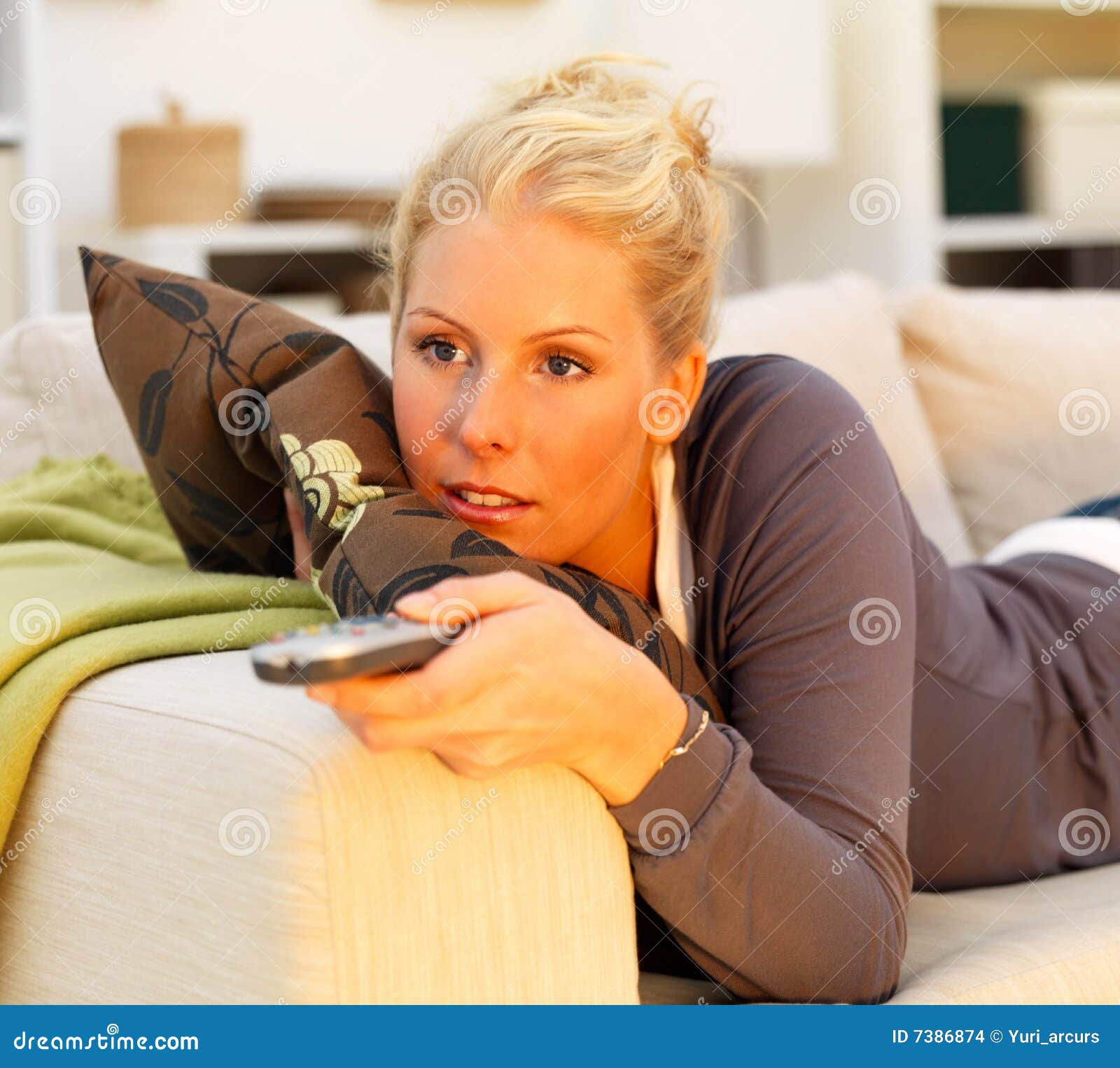Young Lady Using Remote while Resting on Couch Stock Photo - Image of ...
