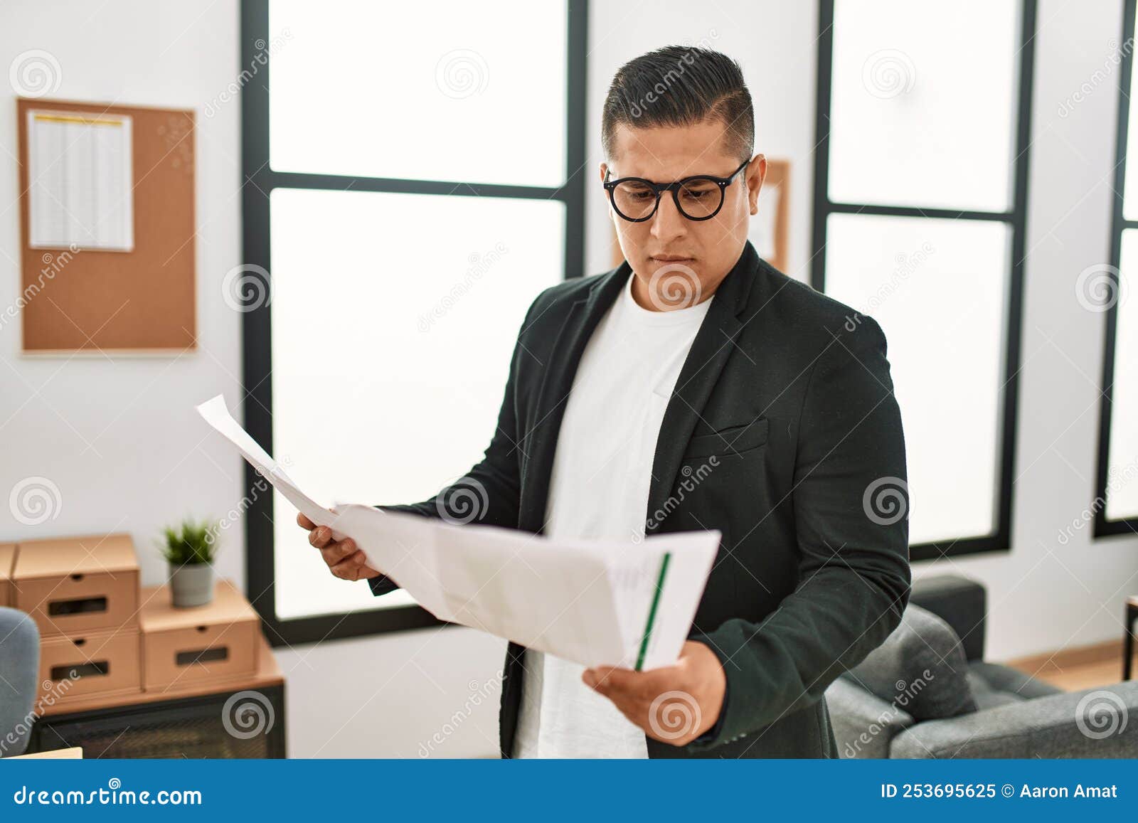 Young Latin Businessman with Serious Expression Reading Paperwork ...