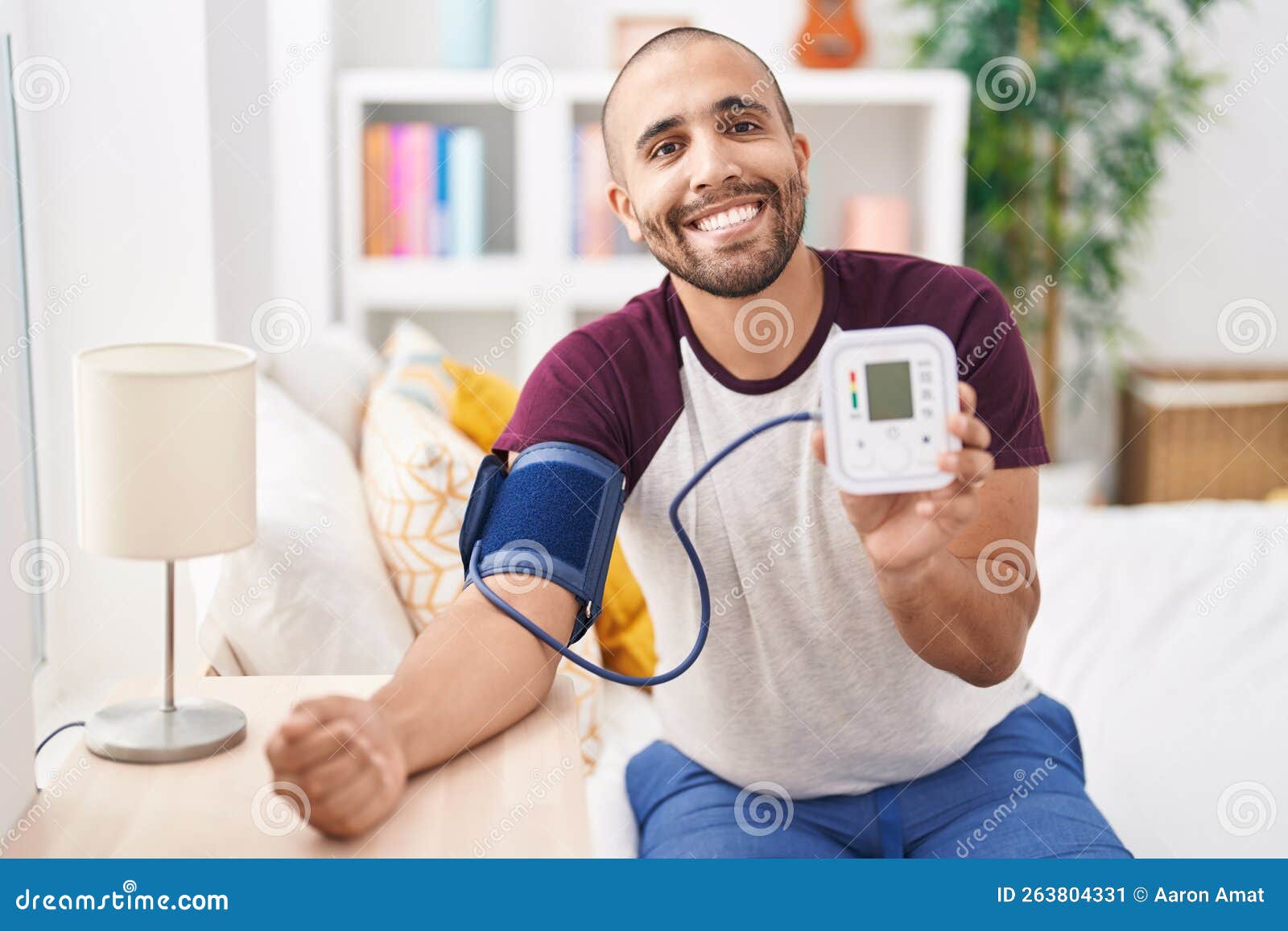 Young Latin Man Measuring Pulse Using Tensiometer at Bedroom Stock ...