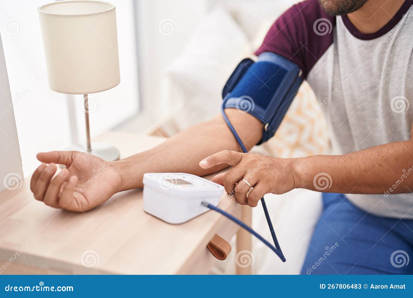 Young Latin Man Measuring Pulse Using Tensiometer at Bedroom Stock ...