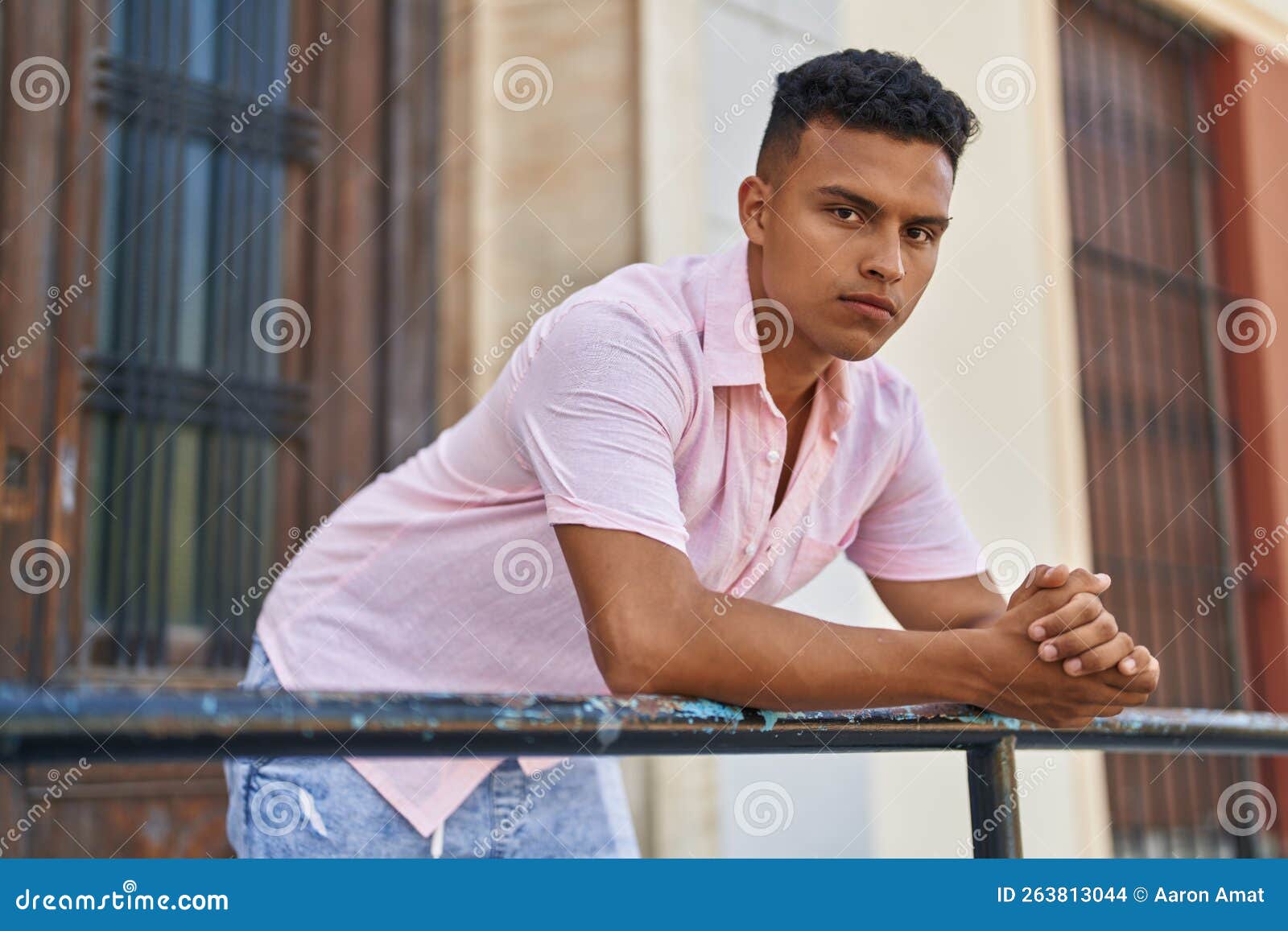 Young Latin Man with Relaxed Expression Leaning on Balustrade at Street ...