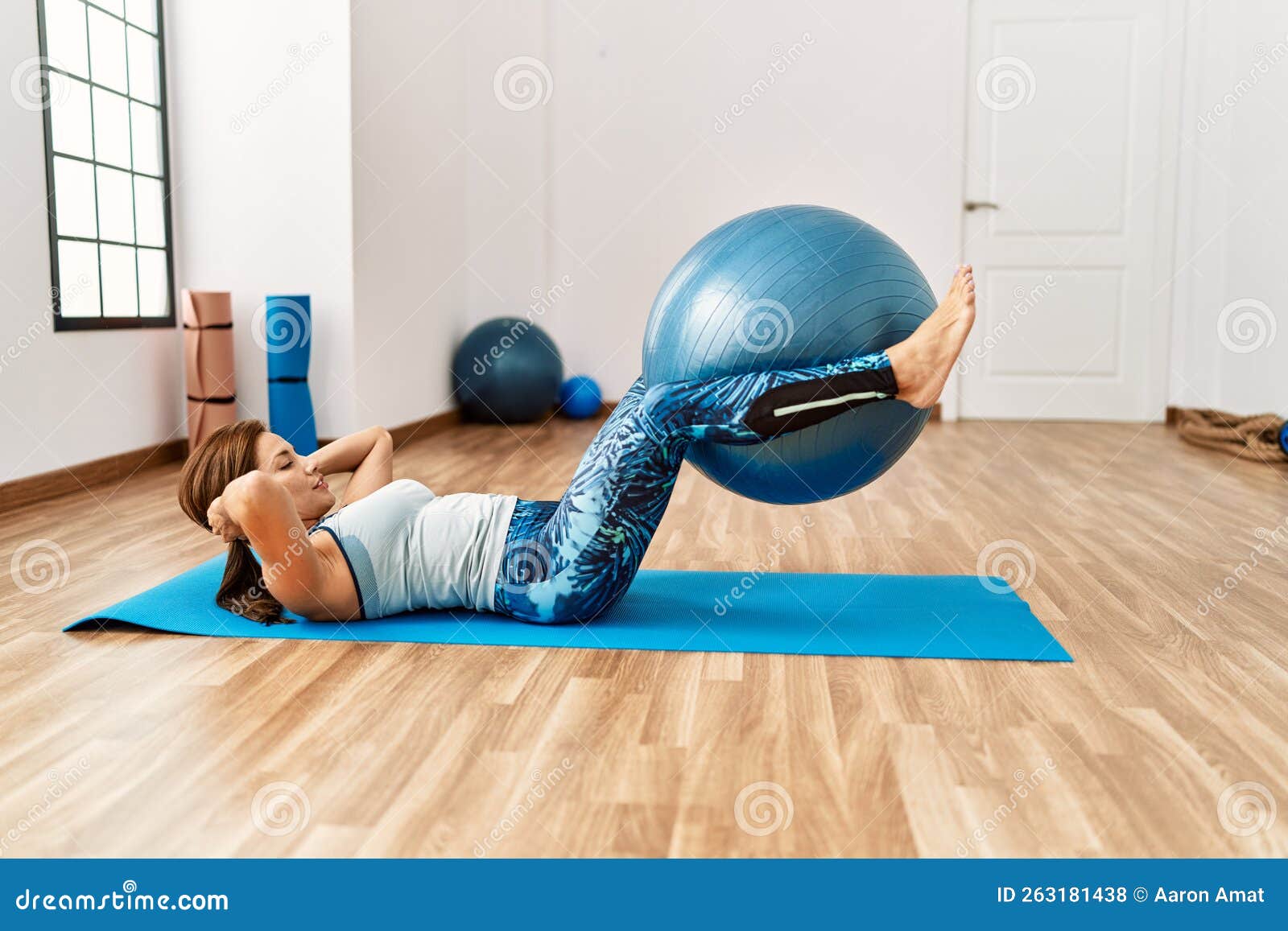 Young Latin Woman Training Abs Exercise Using Ball at Sport Center ...