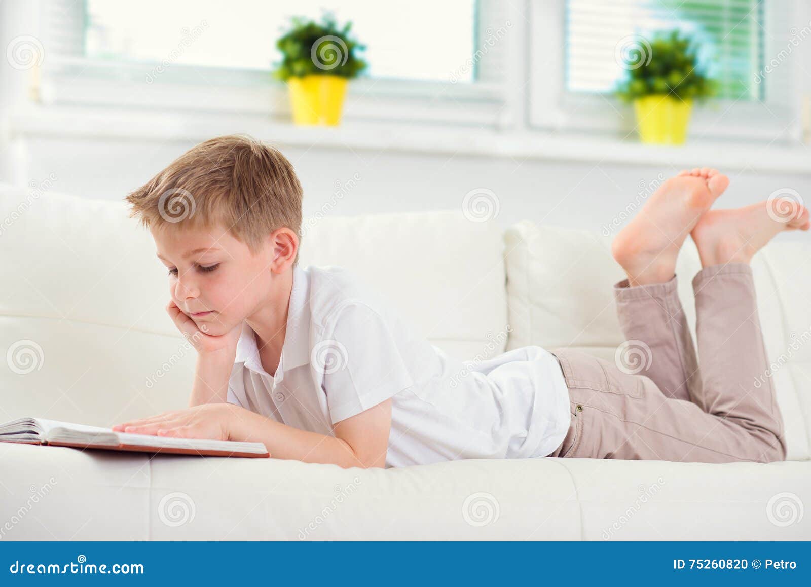 Young Little Boy Reading Book on Sofa at Home Stock Photo - Image of ...